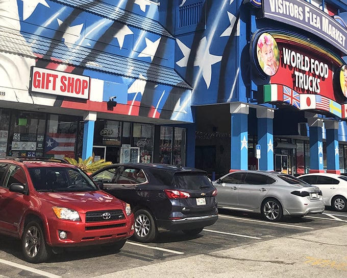 The star-spangled exterior of Visitors Flea Market promises patriotic bargain hunting with its bold blue facade and "WORLD FOOD TRUCKS" sign beckoning hungry shoppers.