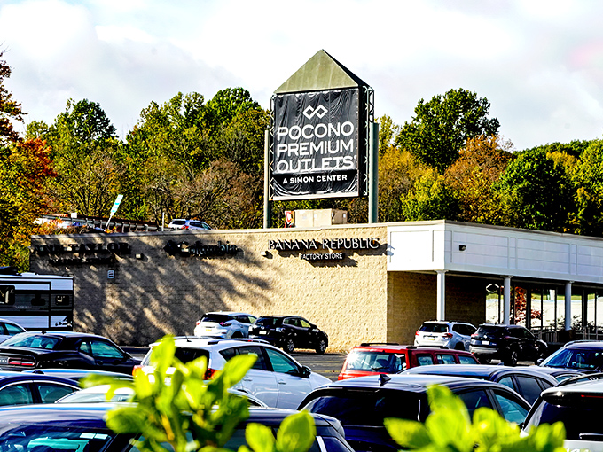The iconic Pocono Premium Outlets sign stands tall against the mountain backdrop, promising retail adventures and wallet-friendly treasures within.