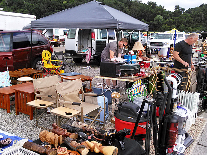 Treasure hunting begins under blue canopies where clothing racks stand like sentinels guarding hidden gems. The weekend ritual of discovery unfolds one table at a time.