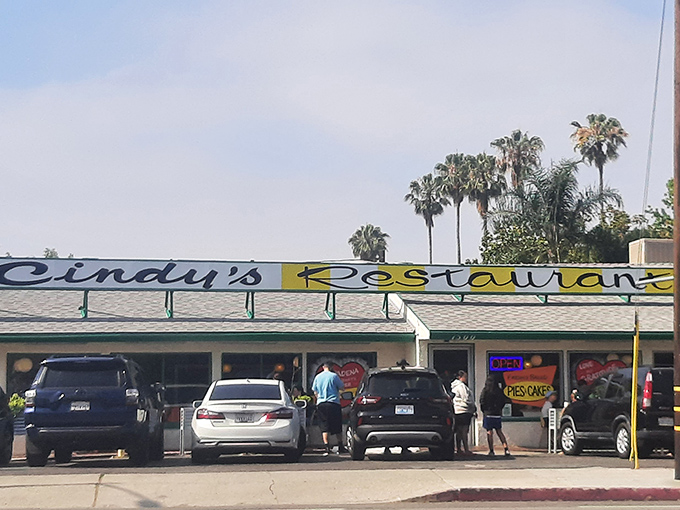 The classic yellow sign beckons like a time machine to simpler days. Cindy's exterior promises comfort food treasures beneath those palm trees.