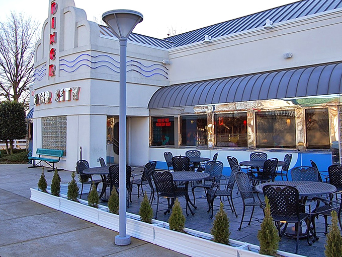 The sleek, retro-modern exterior of River City Diner beckons with its distinctive blue trim and inviting patio seating—a roadside oasis for hungry travelers.