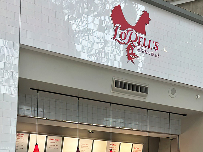 The iconic red rooster logo of LoRell's Chicken Shack stands out against pristine white tiles, beckoning chicken lovers like a culinary lighthouse.