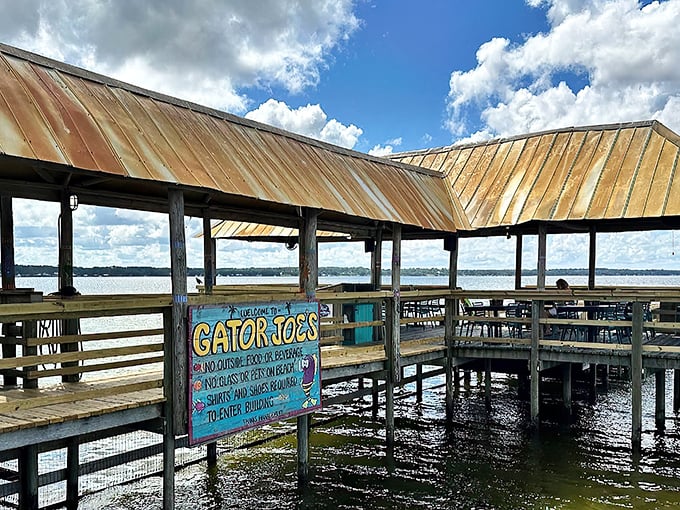 The wooden walkway to Gator Joe's feels like the entrance to a secret Florida treasure – palm trees standing guard as you approach seafood paradise.