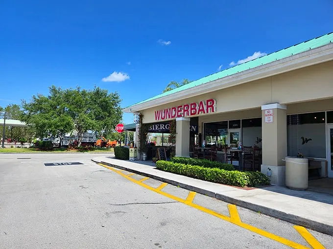 The inviting entrance to Wunderbar beckons with its vibrant blue "BIERGARTEN" sign and climbing vines—Bavaria's warm embrace in sunny Florida.