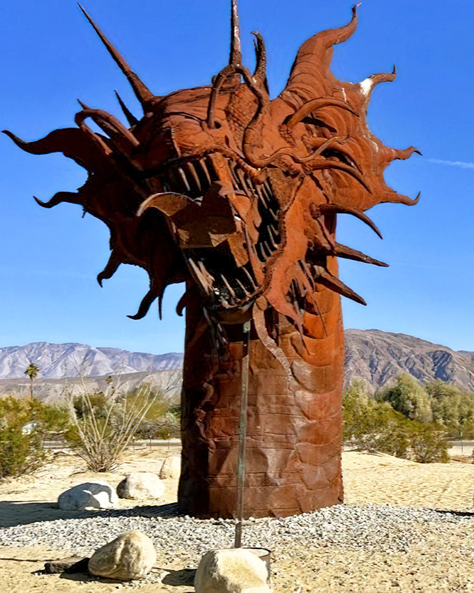 The fearsome dragon of Galleta Meadows emerges from the desert floor, its rust-colored scales glinting under the California sun like some ancient guardian awakened.