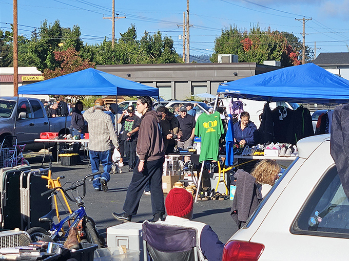Treasure hunters navigate a sea of blue canopies, where one person's castoffs become another's prized possessions. Portland's weekend ritual of discovery unfolds.