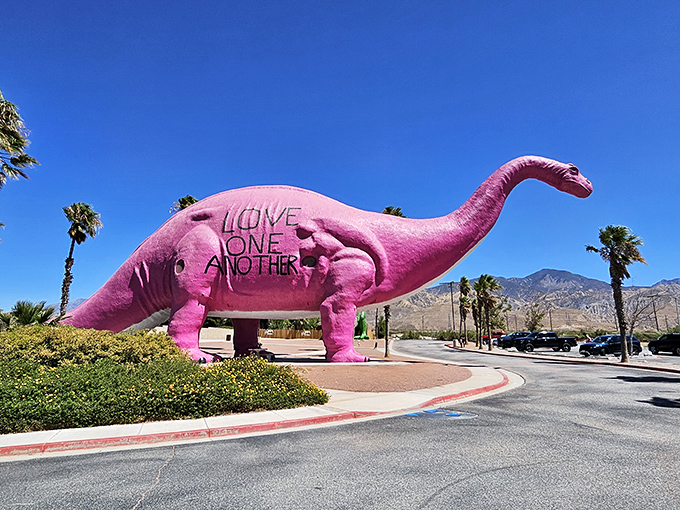 The famous pink Apatosaurus stands proudly against the desert sky, sporting a message of love that's as enormous as its prehistoric proportions.