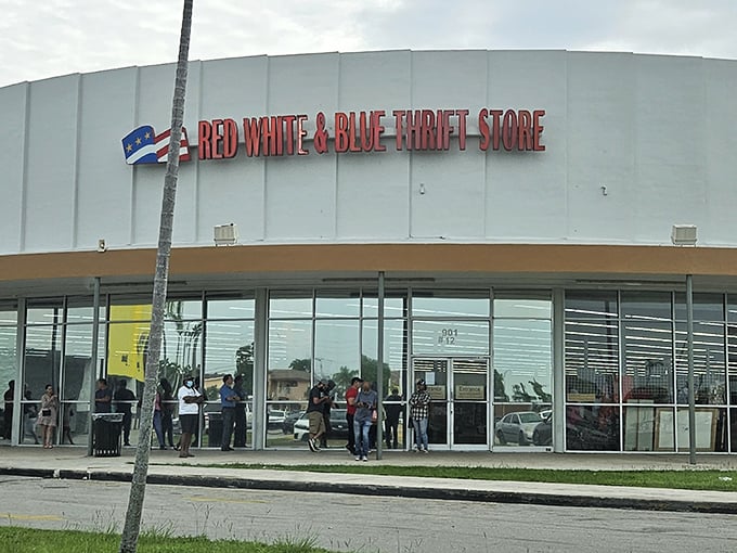 The iconic white exterior of Red White & Blue Thrift Store stands like a retail fortress against the Florida sky, promising treasures within.
