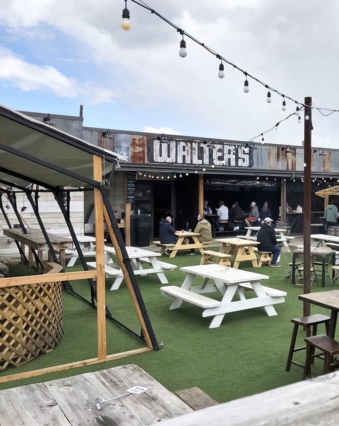 Walter's rustic exterior beckons with string lights and picnic tables, creating a backyard BBQ vibe that says "come hungry, leave happy."
