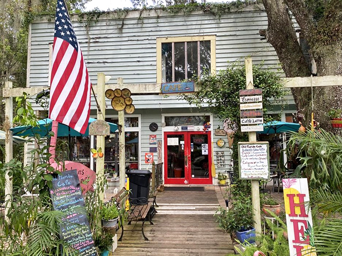 The mint-green exterior with its vibrant red door isn't just inviting—it's practically shouting "Get in here and eat something delicious!" through the Spanish moss.