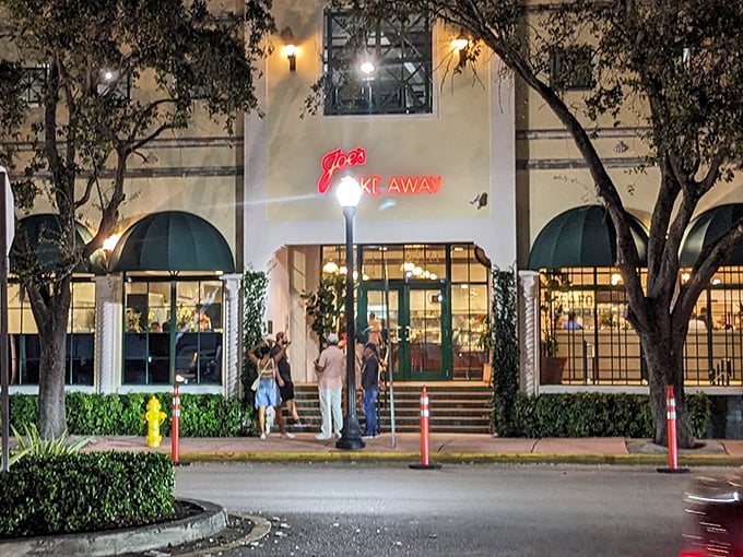 The iconic green awnings of Joe's Take-Away beckon like an old friend at twilight, promising seafood treasures within this Miami Beach landmark.