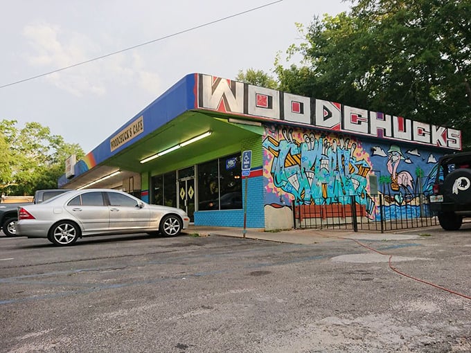 The vibrant blue exterior of Woodchuck's Cafe announces itself with colorful street art and a distinctive green awning—Tallahassee's breakfast rebellion in architectural form.