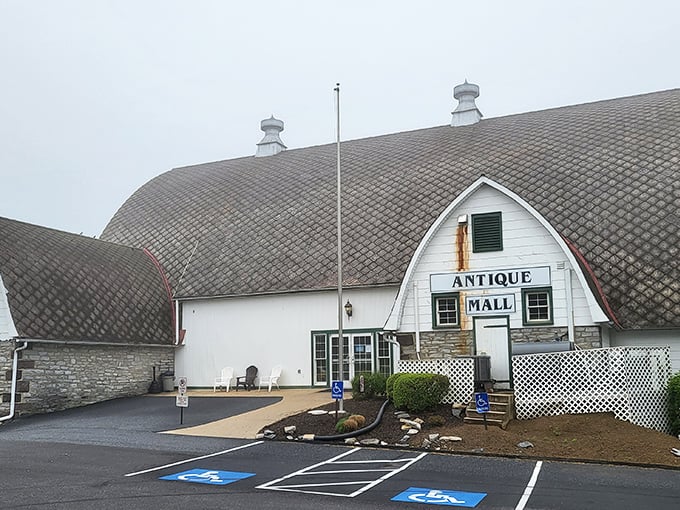 The iconic barn-shaped Crossroads Antique Mall stands like a beacon for treasure hunters, its curved roof promising adventures in antiquing beneath Pennsylvania skies.