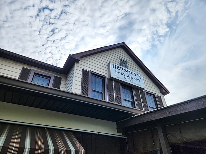 The classic yellow and brown exterior of Hershey's Restaurant stands like a beacon for fried chicken pilgrims, complete with lush hostas and welcoming striped awnings.