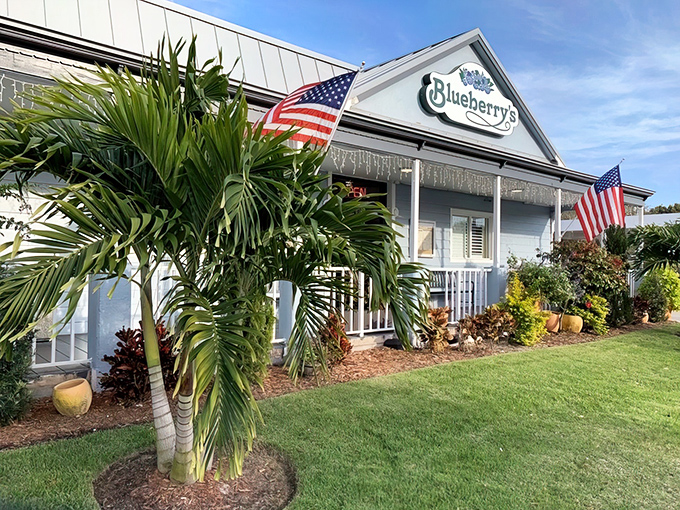 The classic white exterior with American flags and tropical landscaping says "come on in" before you've even parked your car.