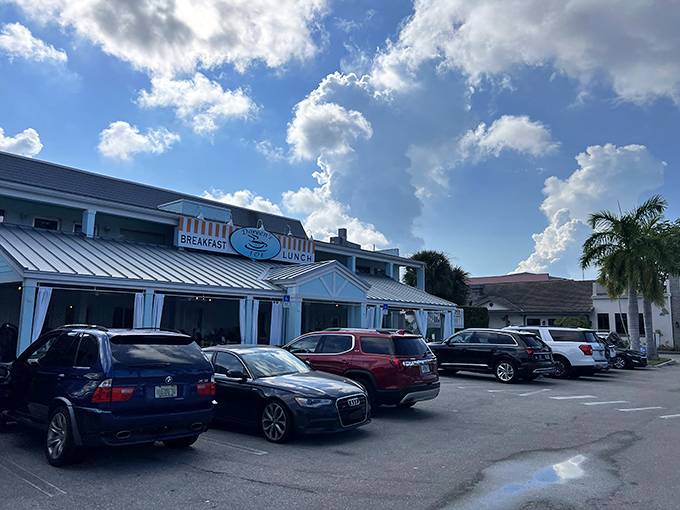 The blue and white façade with those cheerful orange-striped awnings practically whispers, "Your morning is about to get significantly better." Welcome to breakfast paradise.
