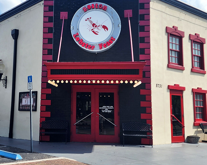 The unmistakable red and white façade of Boston Lobster Feast stands like a lighthouse for seafood lovers, beckoning with its giant lobster sign.