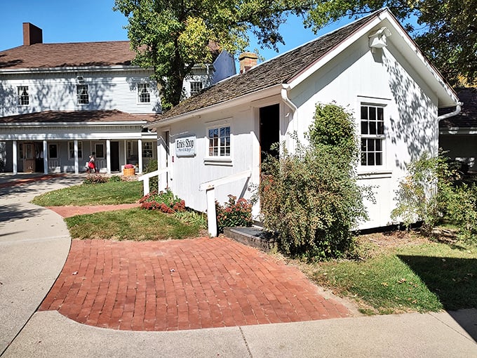 The charming white exterior of The Barn Restaurant's gift shop welcomes visitors with brick pathways and colorful flower beds—a prelude to the comfort food paradise within.