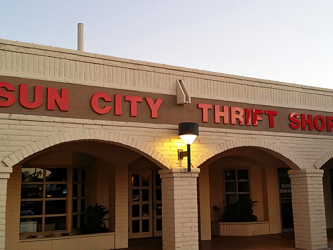The iconic Sun City Thrift Shop facade welcomes treasure hunters with its distinctive Spanish-style architecture and desert palm trees.