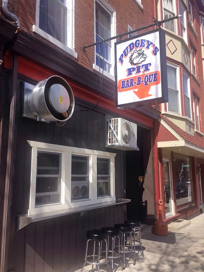 The unassuming storefront of Pudgey's Pit hides barbecue greatness like a superhero's secret identity. That neon "OPEN" sign might as well say "PARADISE."