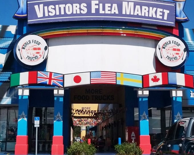 The star-spangled exterior of Visitors Flea Market promises patriotic bargain hunting with its bold blue facade and "WORLD FOOD TRUCKS" sign beckoning hungry shoppers.