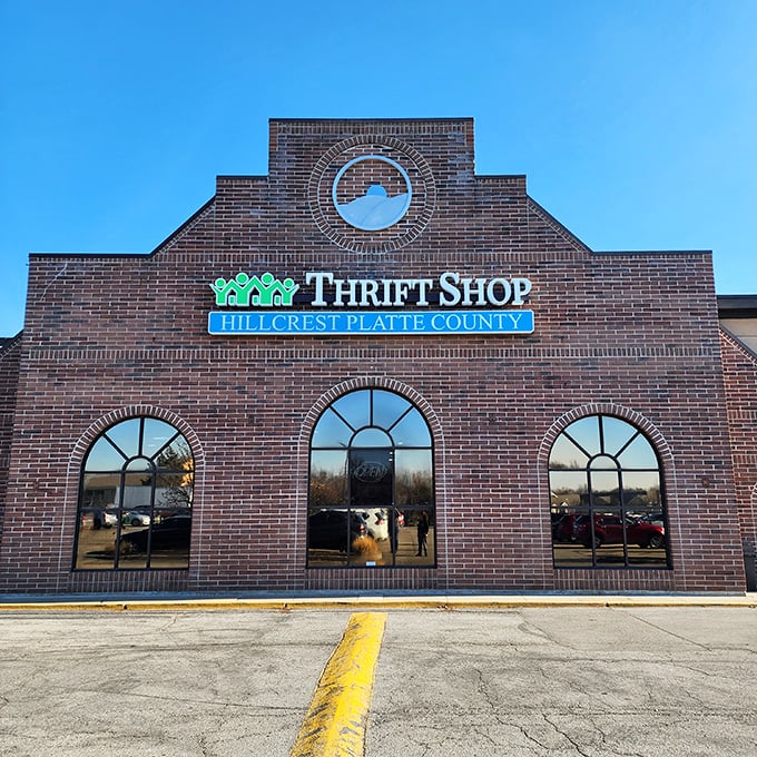 The stately brick facade of Hillcrest Thrift Shop stands like a cathedral of bargains, its arched windows promising treasures within.