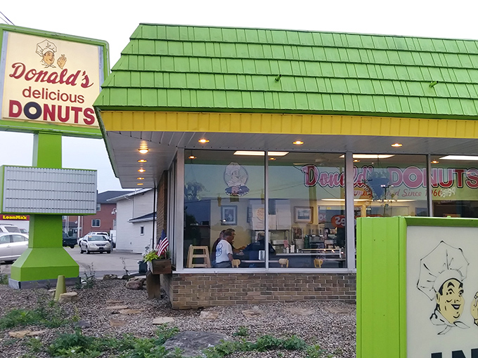 The green-roofed sanctuary of sweetness beckons from Maple Avenue, promising sugary salvation to early risers and donut devotees alike.