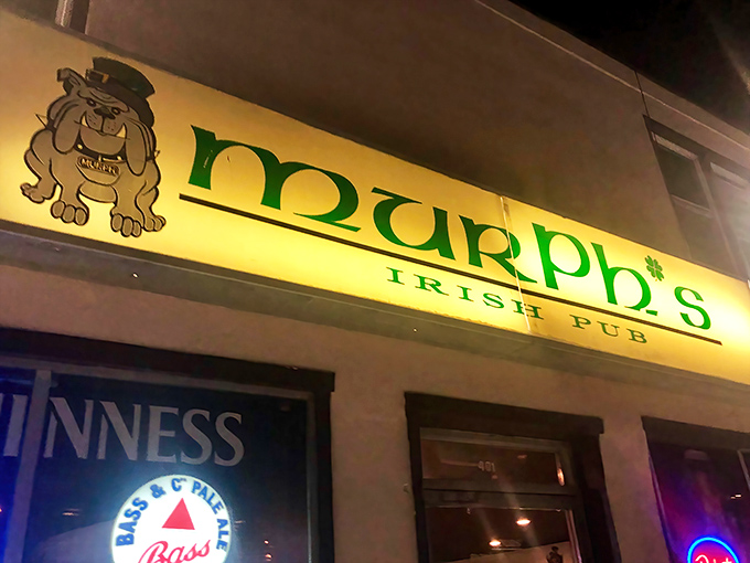 The glowing green sign of Murph's Irish Pub cuts through the night like a beacon for thirsty souls. A wooden bench awaits those needing a breather between pints.