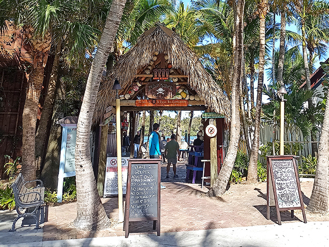 The entrance says it all – palm fronds, weathered wood, and that iconic sign promising the kind of Florida experience you can't manufacture in a boardroom.