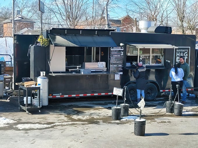 The black food truck of destiny awaits! Ray Ray's Hog Pit's sleek exterior promises smoky treasures within, drawing hungry pilgrims to its window like moths to a delicious flame.