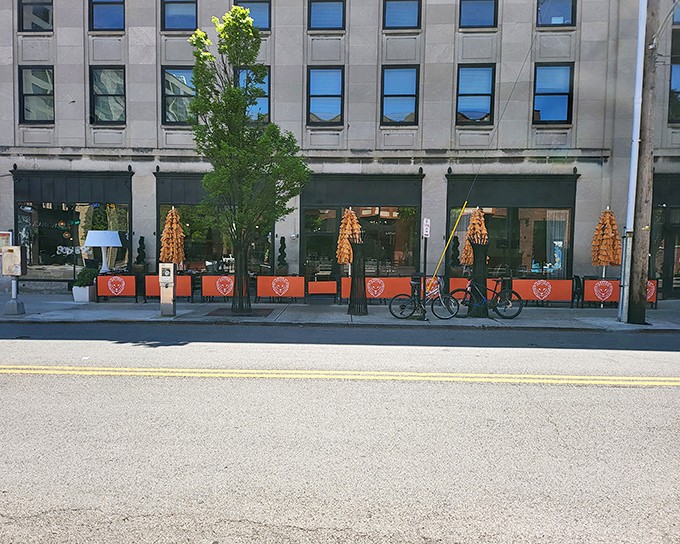 The bright orange patio barriers of Forno Kitchen + Bar stand out against downtown Columbus's urban landscape, beckoning hungry pedestrians like a culinary lighthouse.