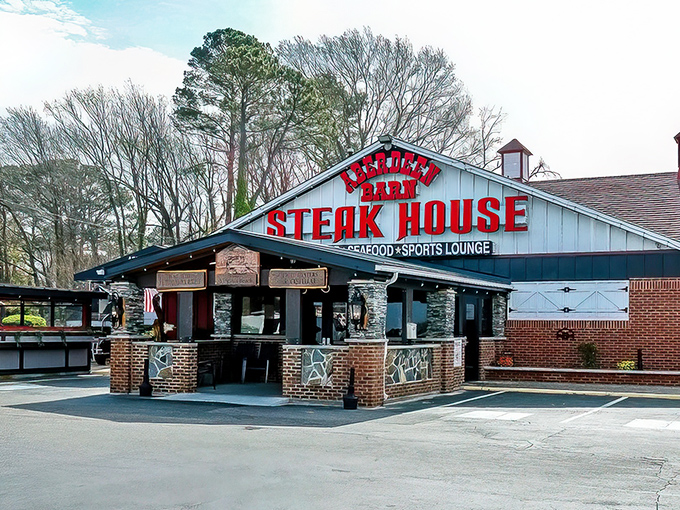 The iconic blue barn with bold red lettering announces your arrival at meat paradise. No trendy minimalism here—just the promise of serious steak.