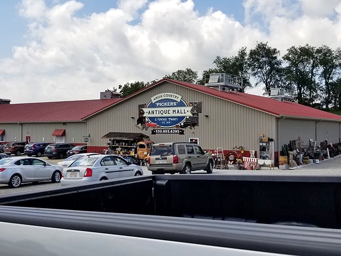 The unassuming exterior hides a wonderland of treasures inside, like finding out your quiet neighbor was once a rock star. Treasure hunters gather at the entrance, already eyeing potential finds.