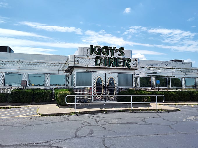 The gleaming metallic exterior of Iggy's Diner shines like a chrome beacon on Route 66, promising nostalgic comfort and culinary treasures within.