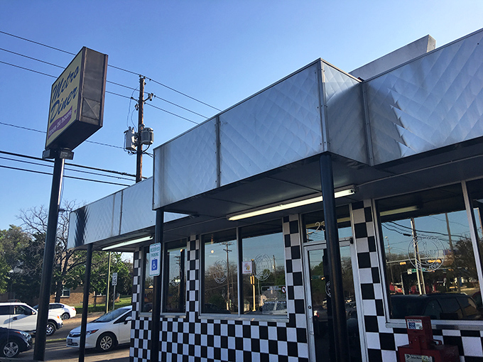 The black and white checkered exterior isn't just nostalgic design—it's a beacon signaling "real food ahead" to hungry Dallas travelers.
