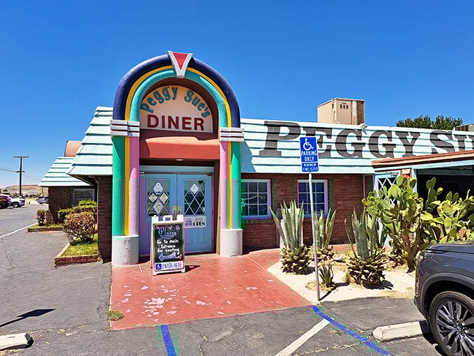 The rainbow-arched entrance to Peggy Sue's stands like a time portal in the Mojave Desert, promising comfort food salvation to weary travelers.