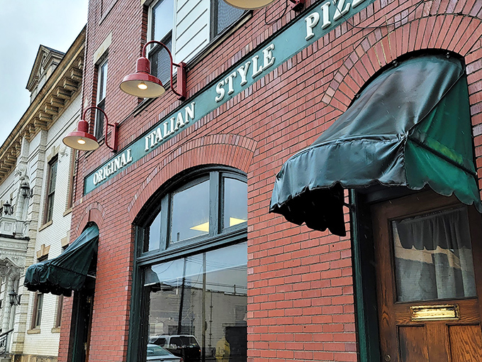The iconic brick façade with green awnings doesn't scream "food destination," but locals know this unassuming storefront houses pizza worth committing minor traffic violations for.