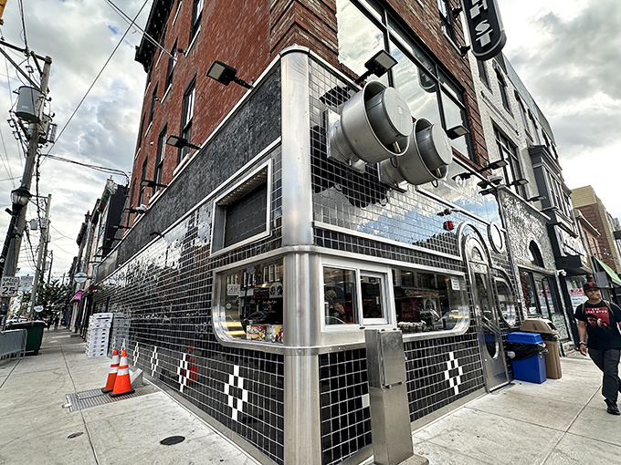 The iconic black-tiled facade of Jim's South St. gleams like a cheesesteak beacon on Philadelphia's famous street, promising delicious adventures within.
