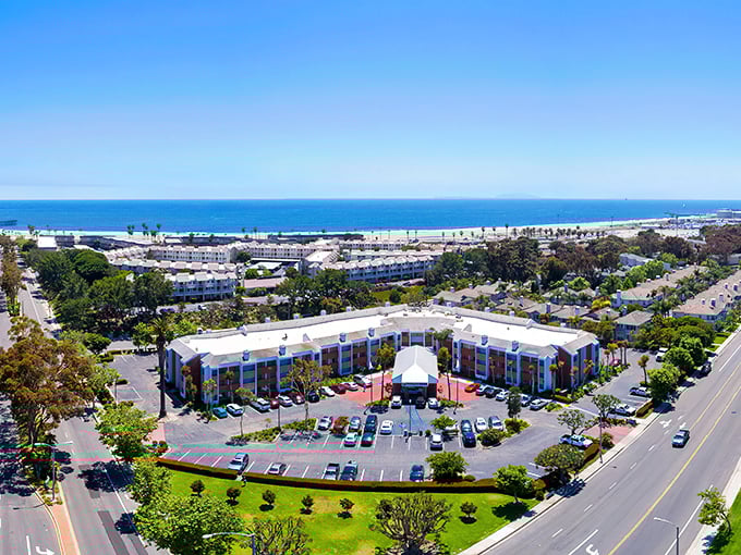 Port Hueneme's aerial view reveals what developers dream about at night—pristine beaches, Spanish-style architecture, and that perfect California coastline stretching into misty mountains.