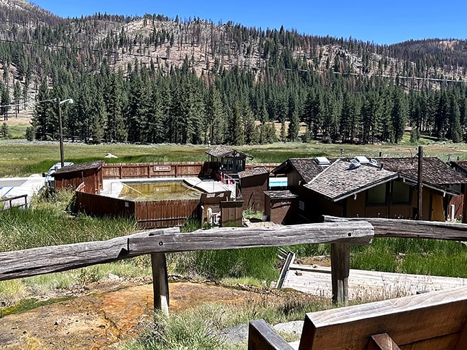 Nature's own infinity pool setup. The rustic hot springs complex sits perfectly framed by towering Sierra pines and dramatic mountain backdrops.