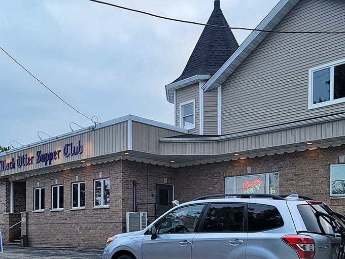 The iconic turret of Black Otter Supper Club stands sentinel over the parking lot—architectural proof that good taste extends beyond the kitchen.