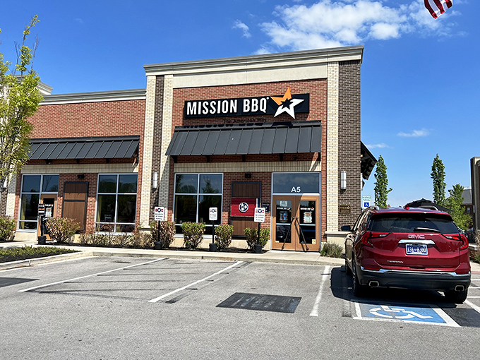 The American flag stands tall outside Mission BBQ, a patriotic beacon for hungry Tennesseans seeking smoky salvation in Murfreesboro's retail landscape.