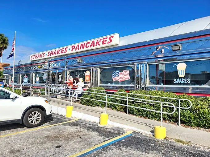 The gleaming silver exterior of All American Diner shines like a time capsule under the Florida sun, promising "STEAKS • SHAKES • PANCAKES" in bold red letters.