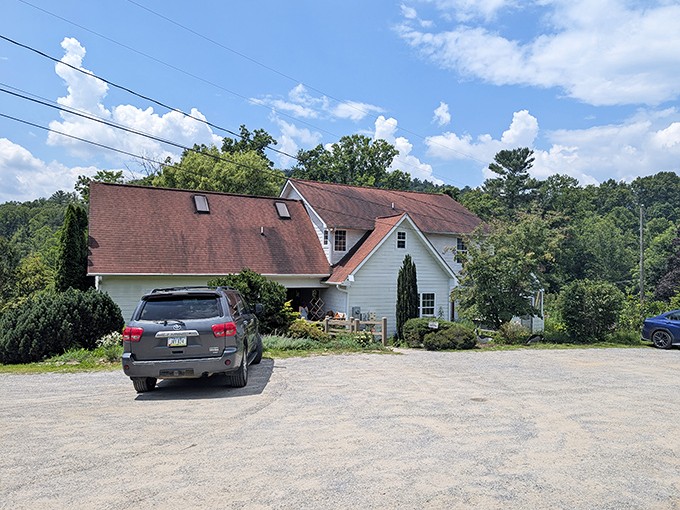 A charming white farmhouse beckons with its stone pathway and "OPEN" sign – like a storybook cottage that happens to make incredible sandwiches.