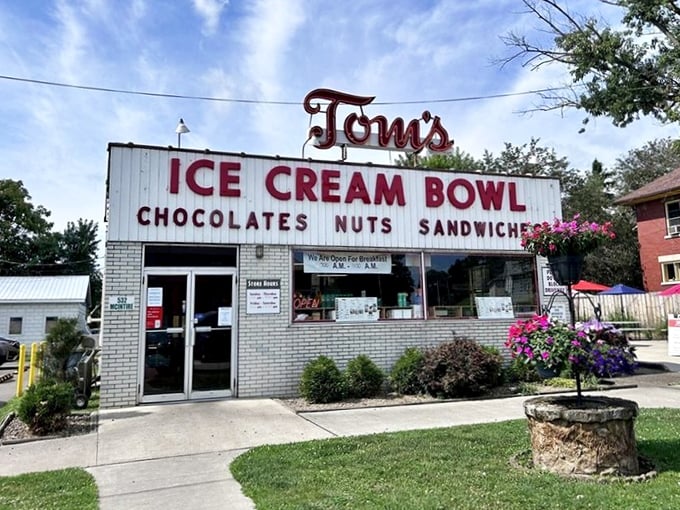 The brick exterior of Tom's Ice Cream Bowl stands as a beacon of sweet nostalgia, complete with mint-green chairs where happiness is served daily.