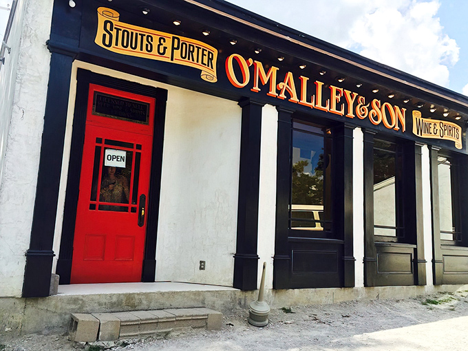 That red door isn't just an entrance—it's a portal to underground beer paradise. O'Malley's classic storefront gives only the slightest hint of what awaits below.