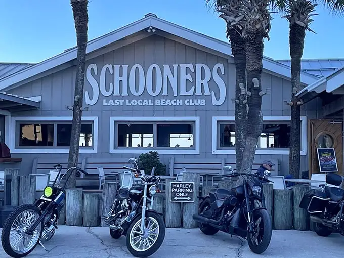 Schooners proudly announces itself as the "Last Local Beach Club," where palm trees stand guard and outdoor seating beckons with the promise of Gulf breezes.