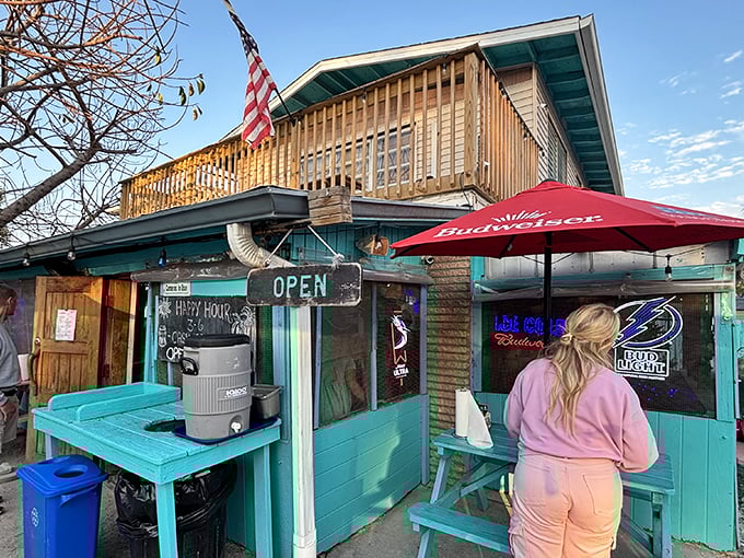 The turquoise-painted shack with wooden deck screams "Florida beach burger joint" louder than a seagull eyeing your fries. Old-school charm personified.