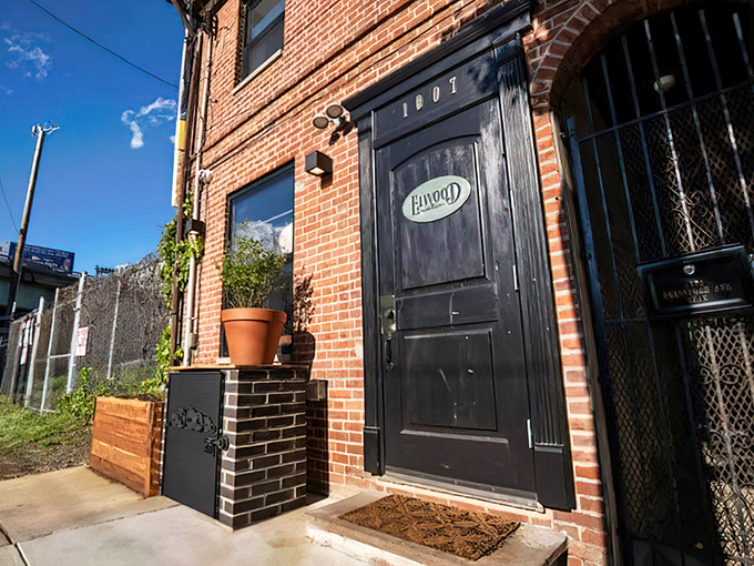 The unassuming entrance to culinary paradise – a black door with a golden Elwood plaque that promises treasures beyond the brick facade.