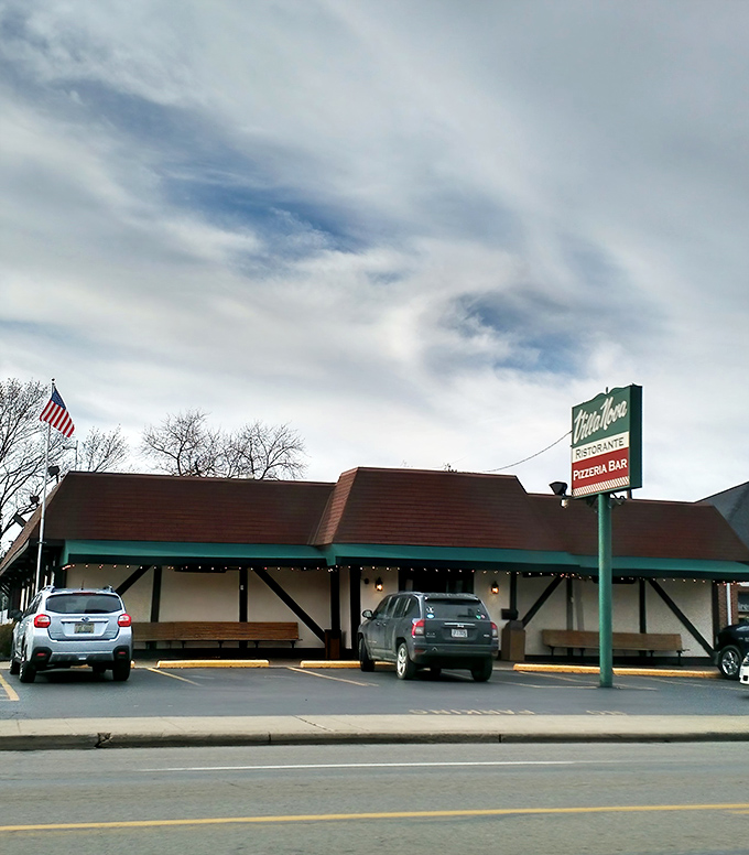 Villa Nova's charming Tudor-style exterior stands like a culinary time capsule, promising Italian delights behind its unassuming façade. The American flag waves a patriotic welcome.
